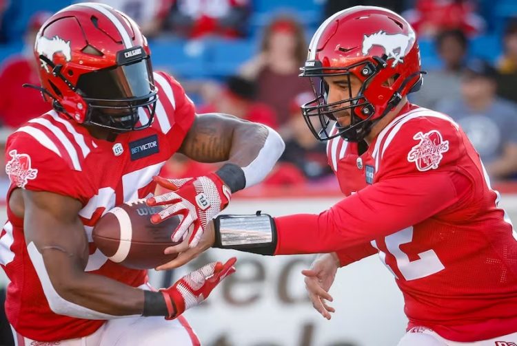 Stampeders QB Jake Maier hands the ball off to RB Ka’Deem Carey during ...